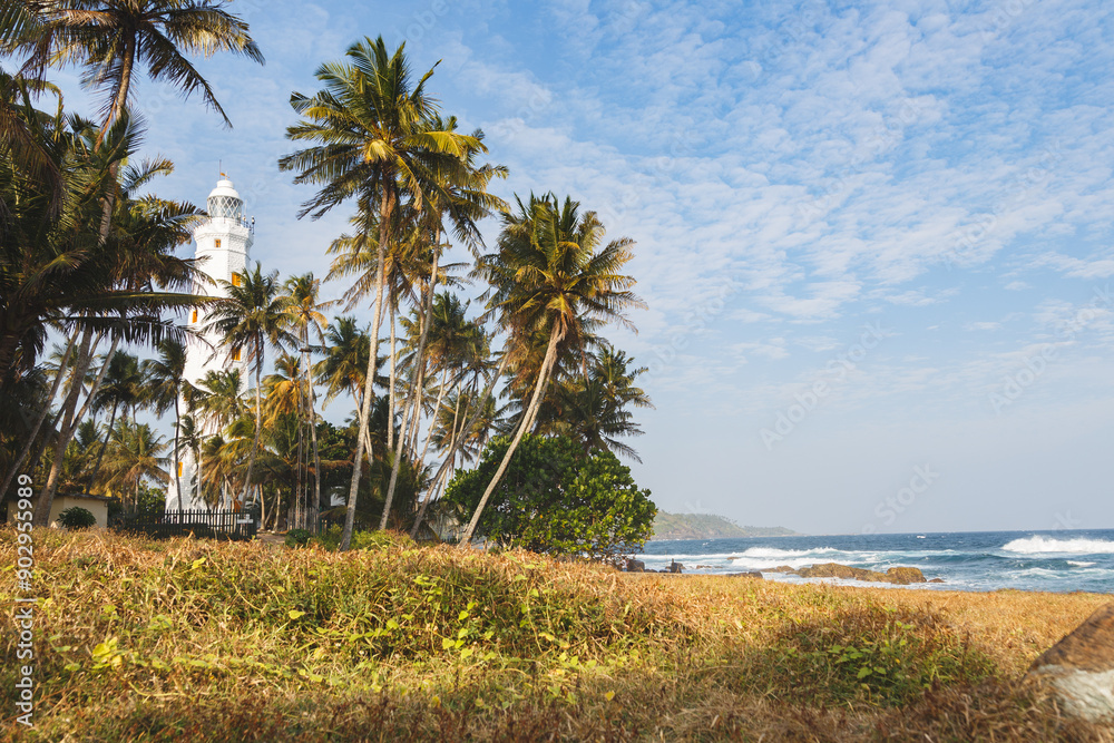 Dondra lighthouse, southern point of Sri Lanka among the green palms on ...