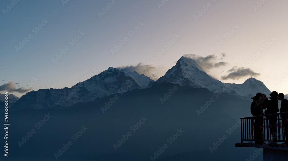 Silhouettes of people standing at the observation tower at Poon Hill ...