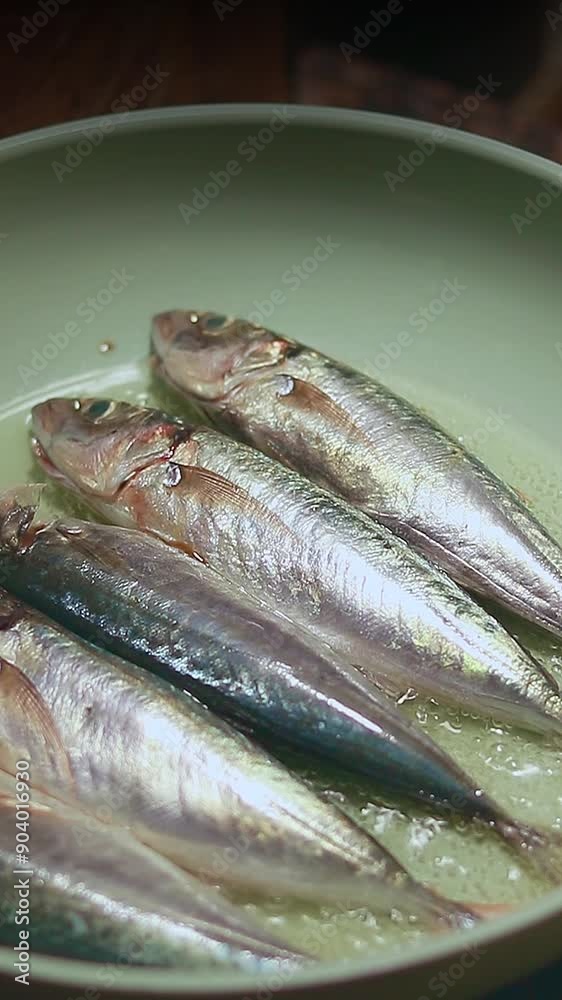 Rows of mackerel scad fish or galongong frying in a pan that shows the ...