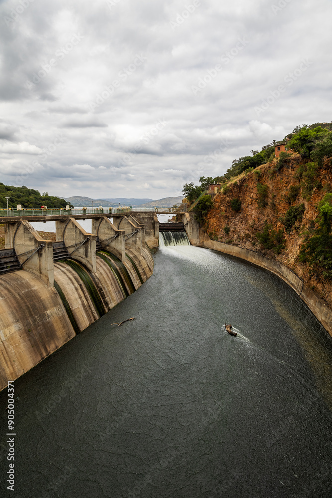 A spillway channel flowing alongside the dam wall and carrying enough ...