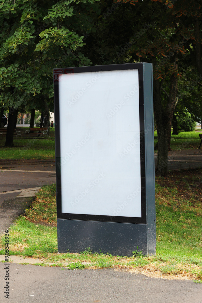 Blank advertising vertical street billboard poster in a green park ...