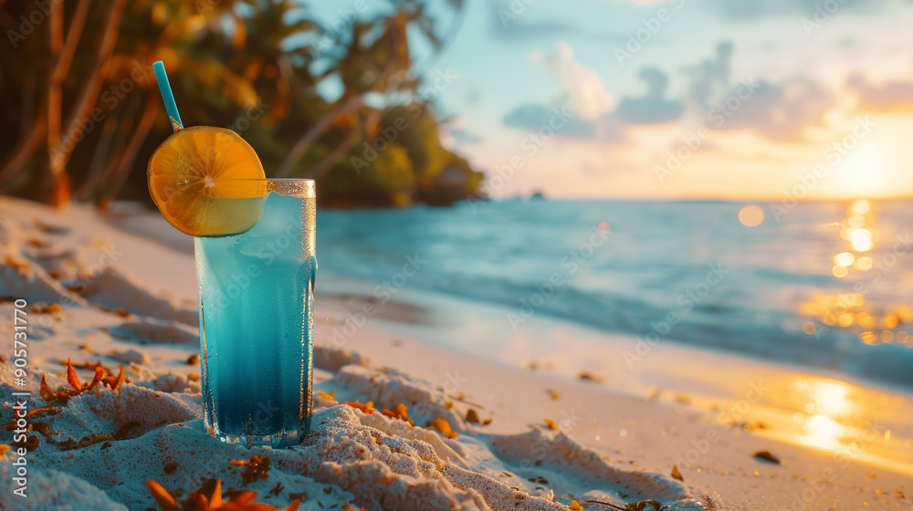 Blue Lagoon cocktail on beach in sand in front of ocean at sunset ...