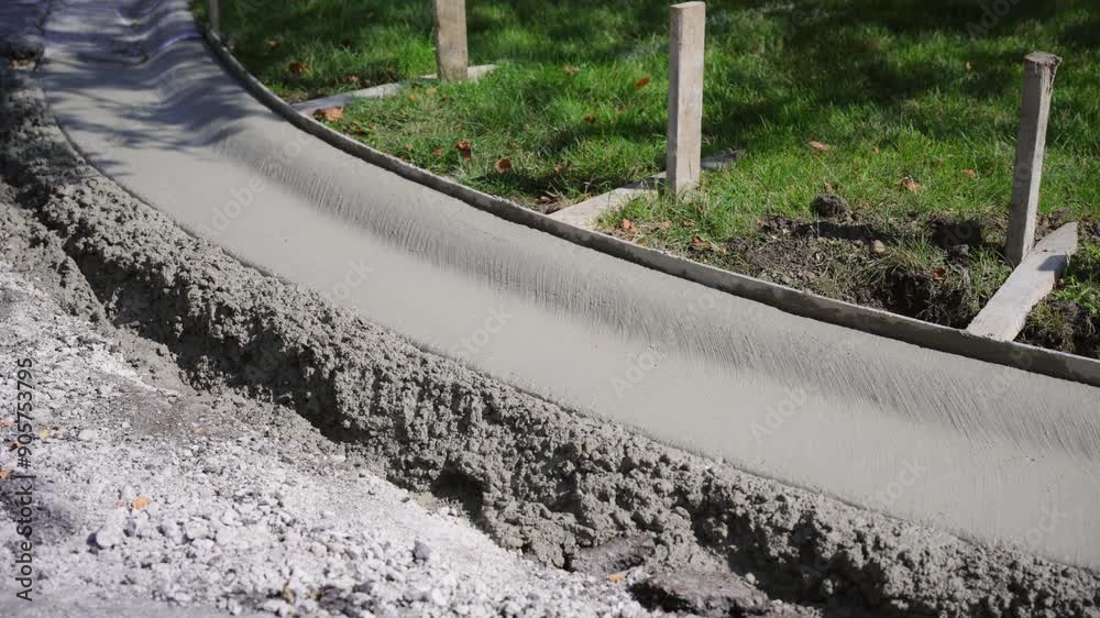 Concrete curb at road construction site. The road is Installation of ...