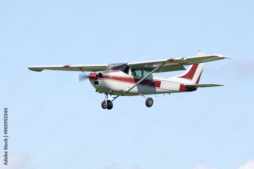 Light general aviation aircraft on appraoch to landing. Red and white ...