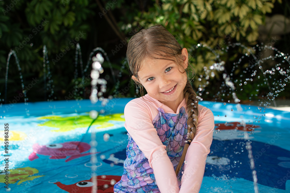 Cute Caucasian little girl playing in a kiddie pool. Summer fun concept ...