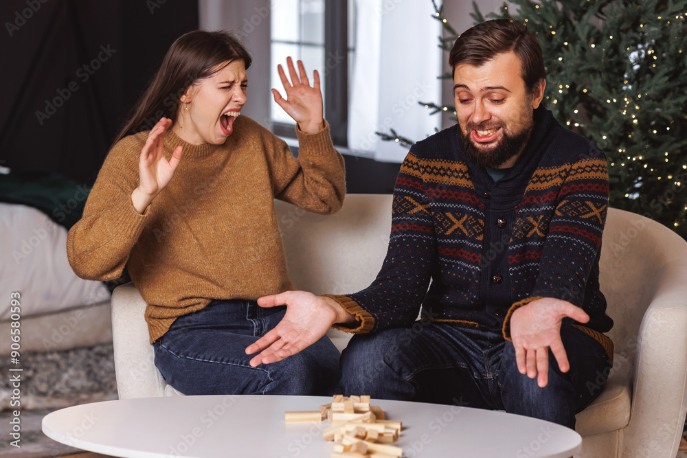 couple plays game board game on the table Jenga Christmas tree. woman ...