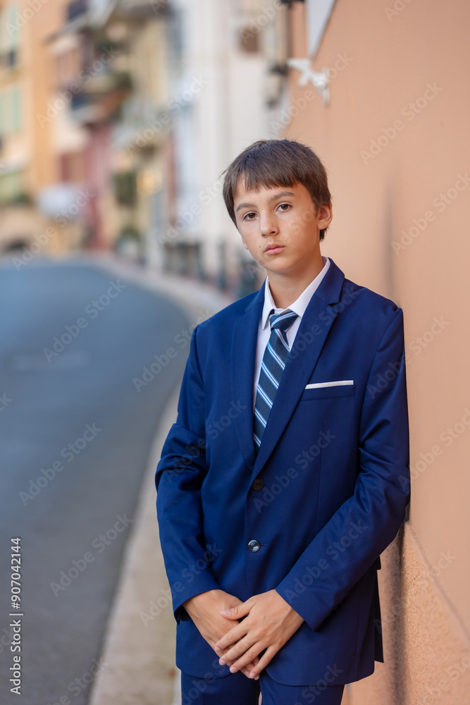 Smart casual children in suits, ties and bows, walking on a narrow ...