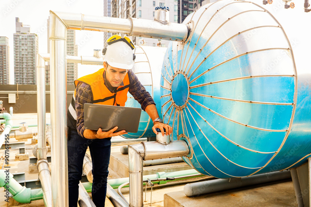 Male HAVC refrigeration system technician holds laptop recording ...