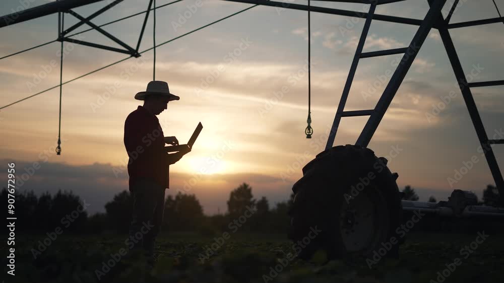 Farmer in soybean field at sunset using laptop. Modern agriculture ...