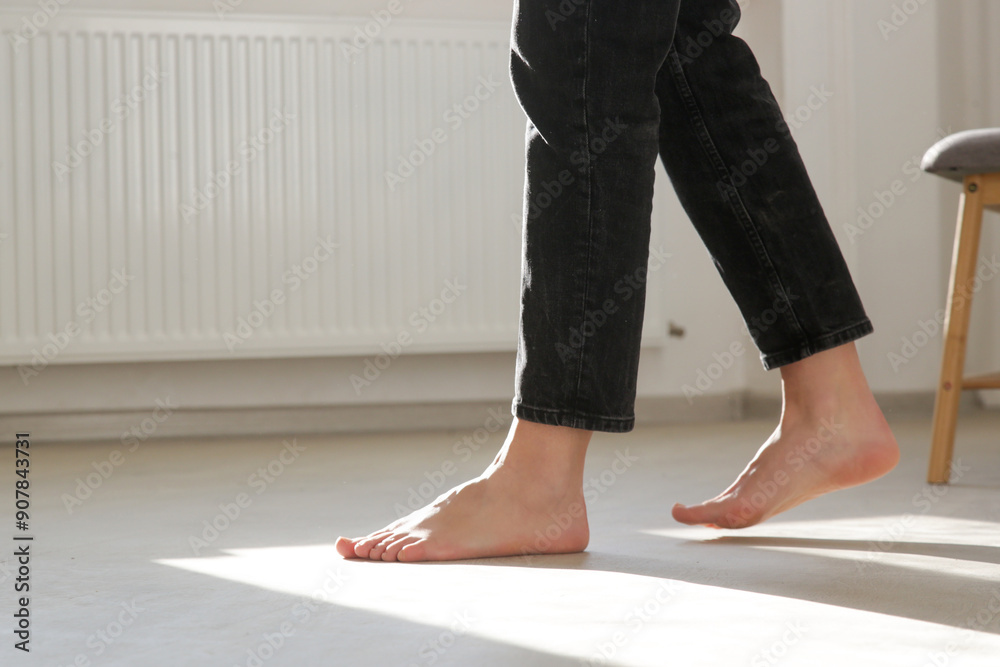 Barefoot woman on the wooden floor. Concept of the underfloor heating ...