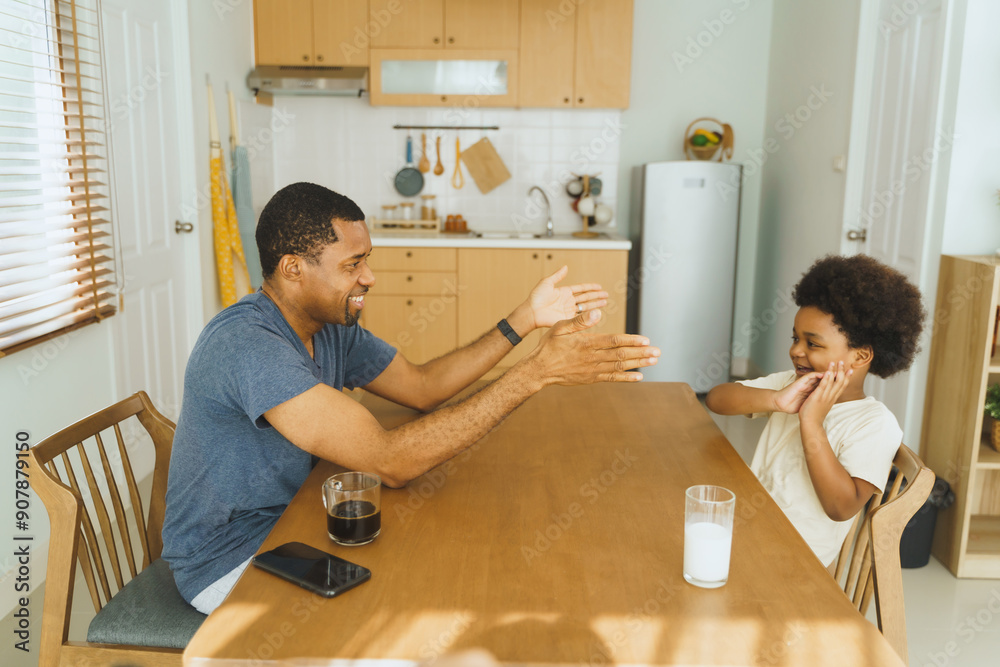 Black African American Father and son clapping hands at kitchen table ...