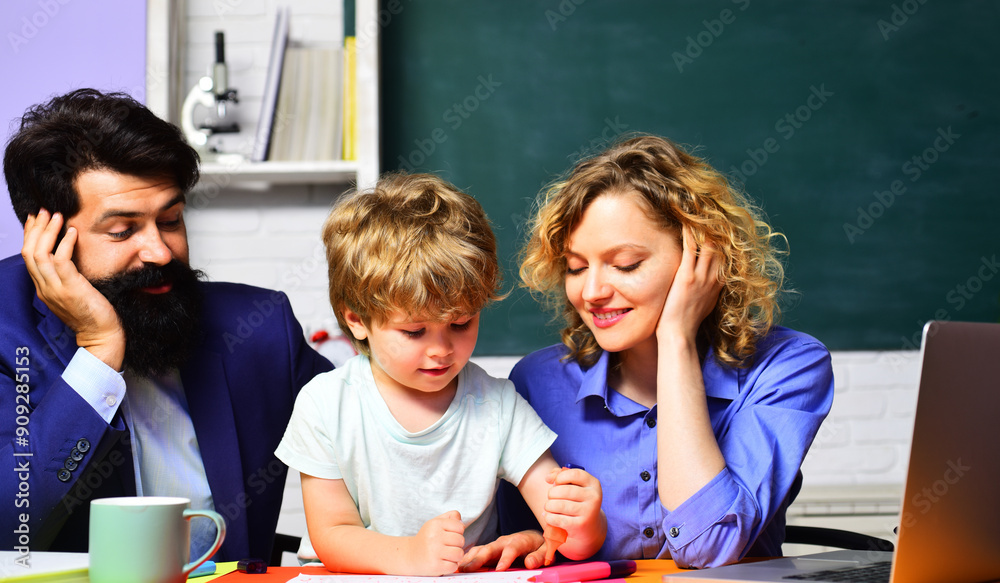 Teachers man and woman helping child from primary school make ...