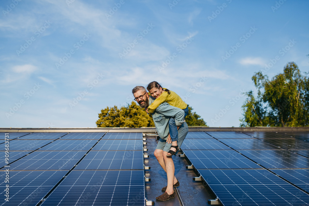 Father with girl on roof with solar panels, piggyback ride. Rooftop ...