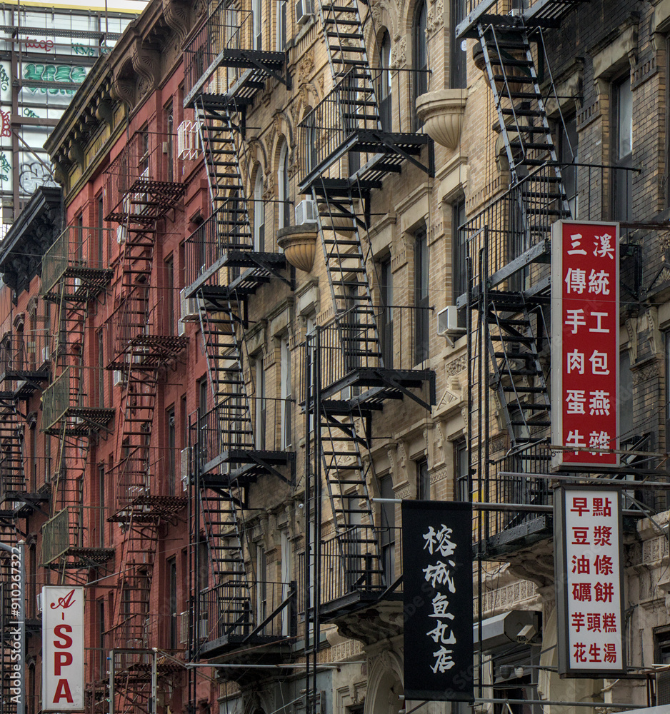 Apartment buildings with fire escapes and store signs written in ...