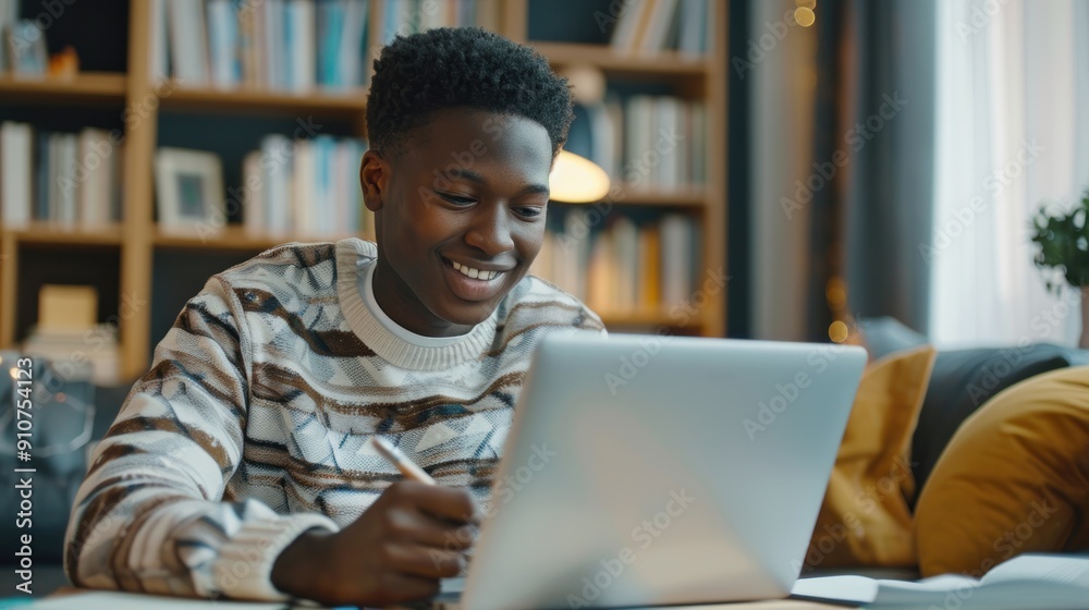 Portrait of teenage black boy using laptop computer at home. A teenage ...
