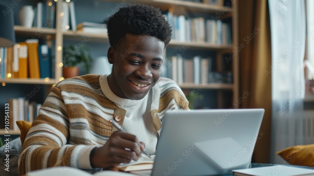 Portrait of teenage black boy using laptop computer at home. A teenage ...