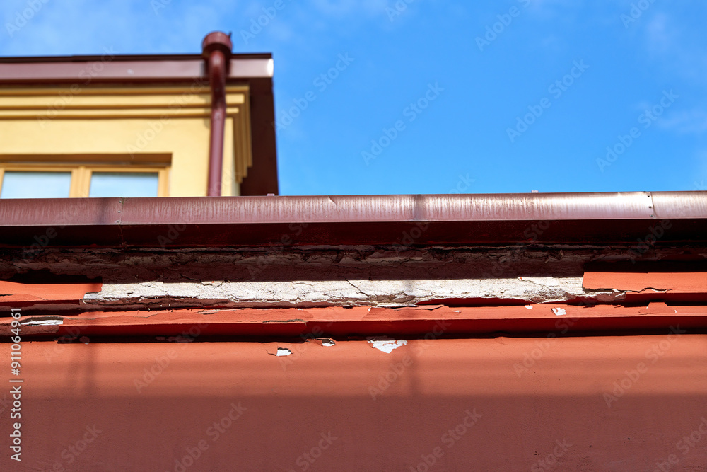 Building with debonded plaster on red wall. Damaged wall with broken ...