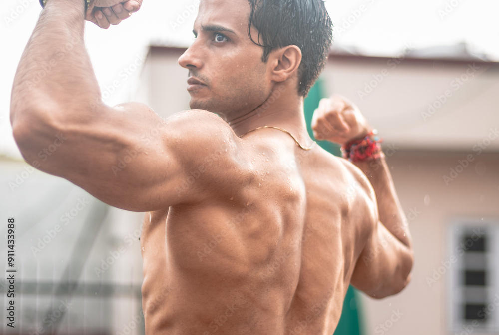A fitness male model flexing outdoors to show his well develops back ...