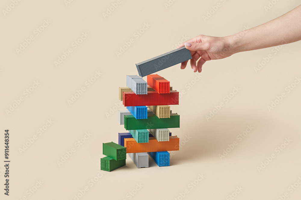 Hand placing grey container on tower build in perpendicular way Stock ...