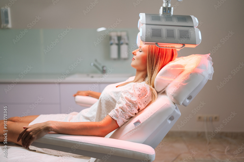 Relaxed blonde female with closed eyes lying on procedure chair having ...