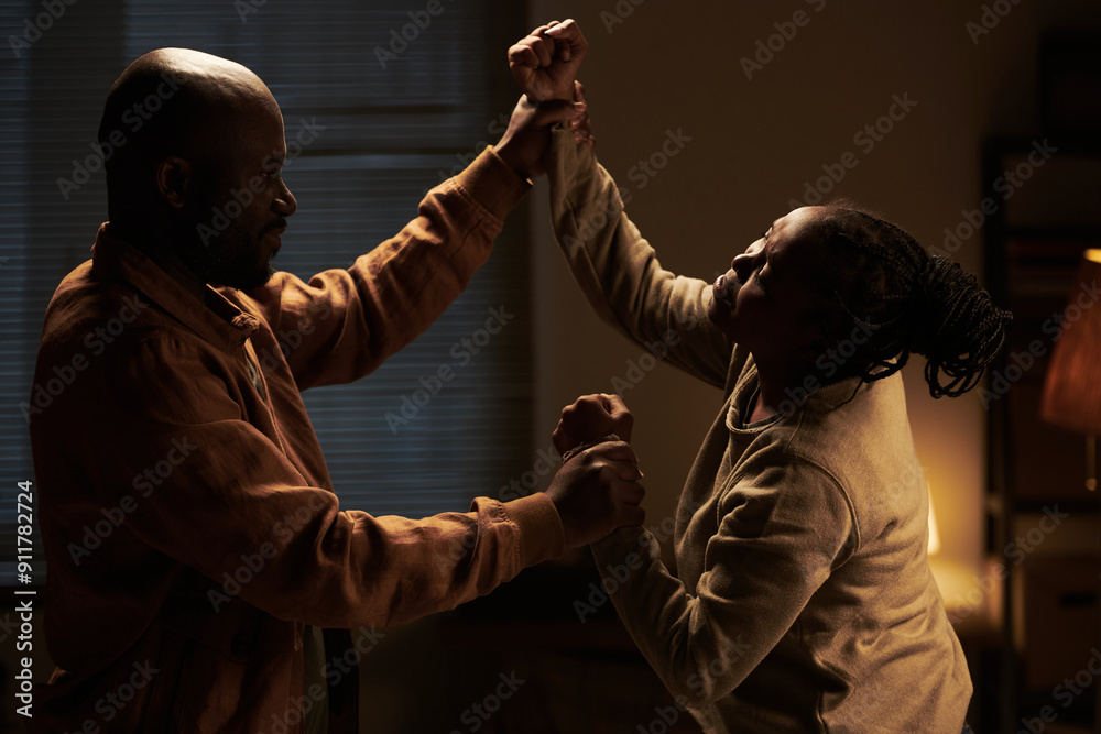 Side view of young African American angry man holding helpless and ...