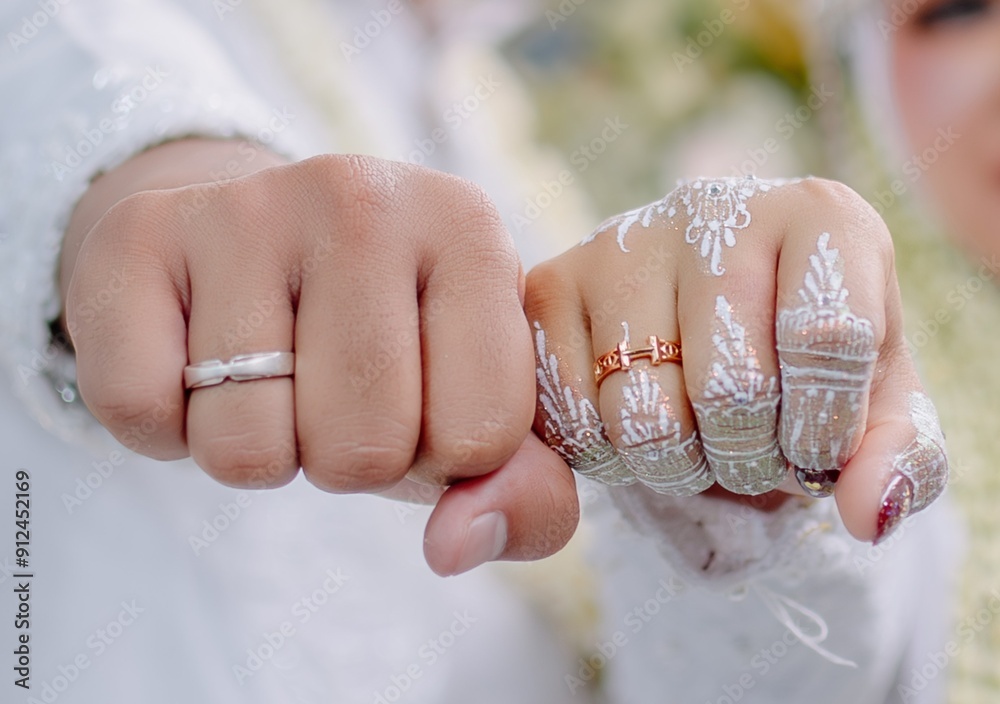 The bride and groom show off their wedding rings by clenching their ...