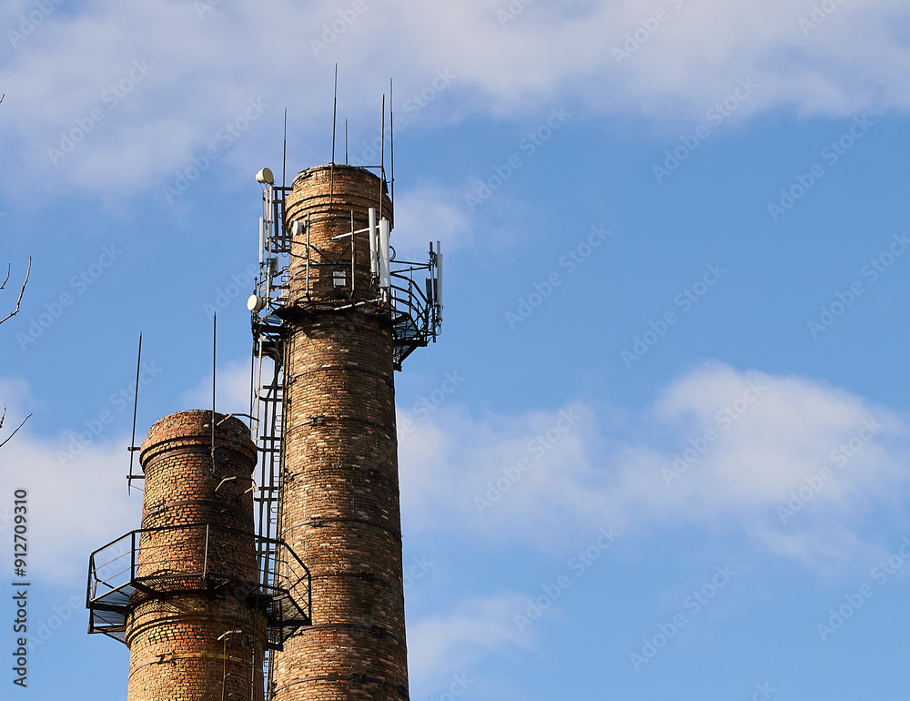 Two cell tower above cellular base station. Brick chimneys of boiler ...