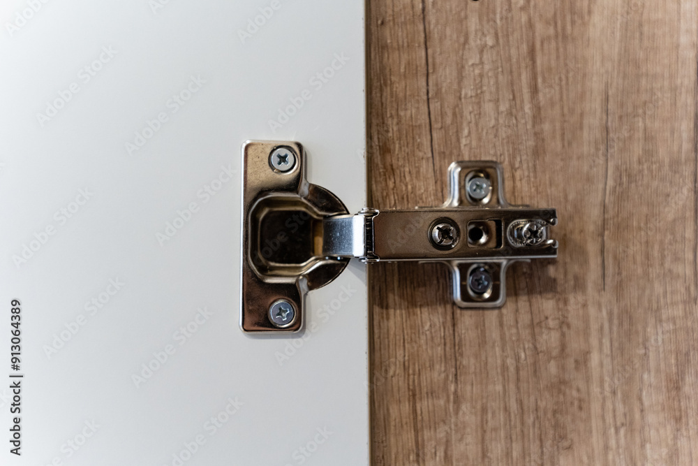 This closeup image vividly displays a modern cabinet hinge that is ...