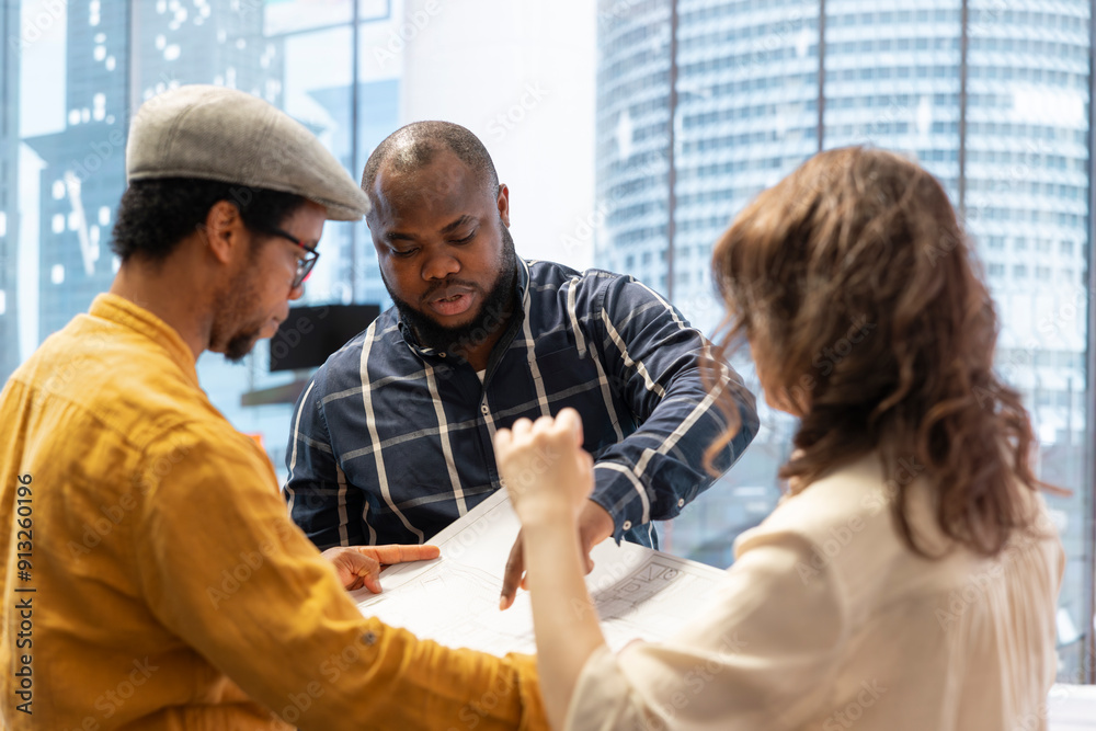 Real estate agent showcasing modern office blueprints to clients ...