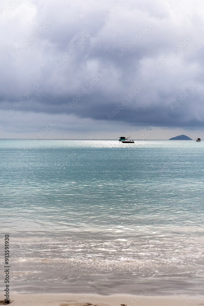 Vertical image with calm view of fishing ships on the sea on the ...