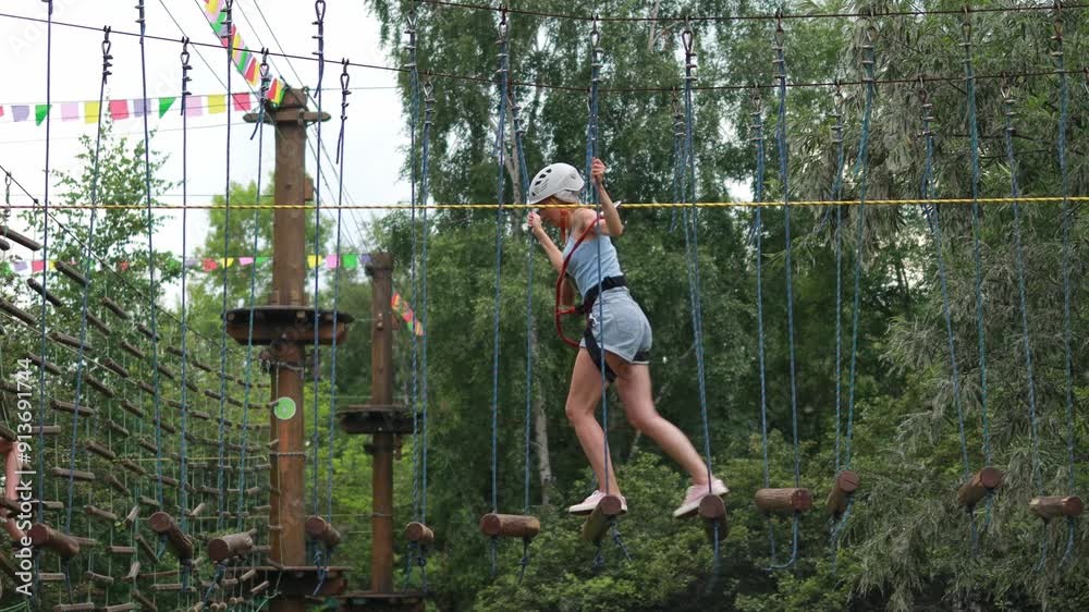 A woman in a protective helmet runs an obstacle course along parallel ...