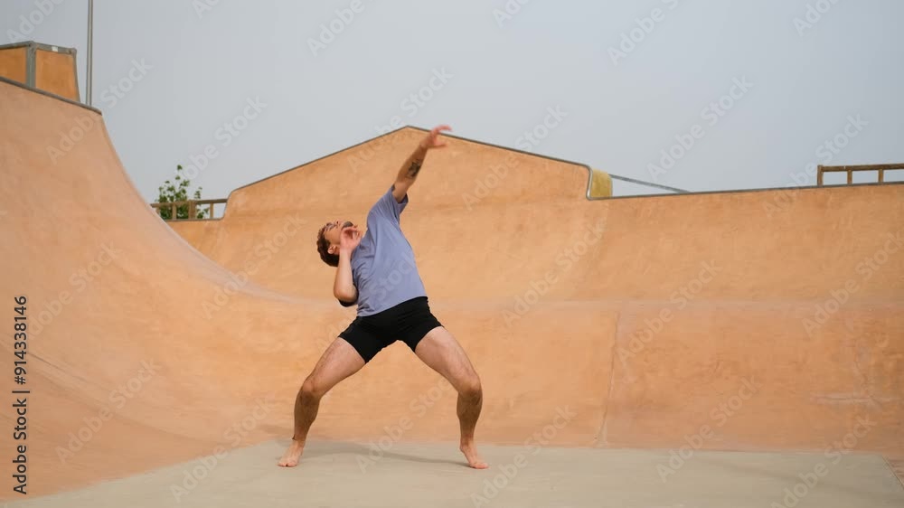 Energetic man dancing with expressive movements in an outdoor skate ...