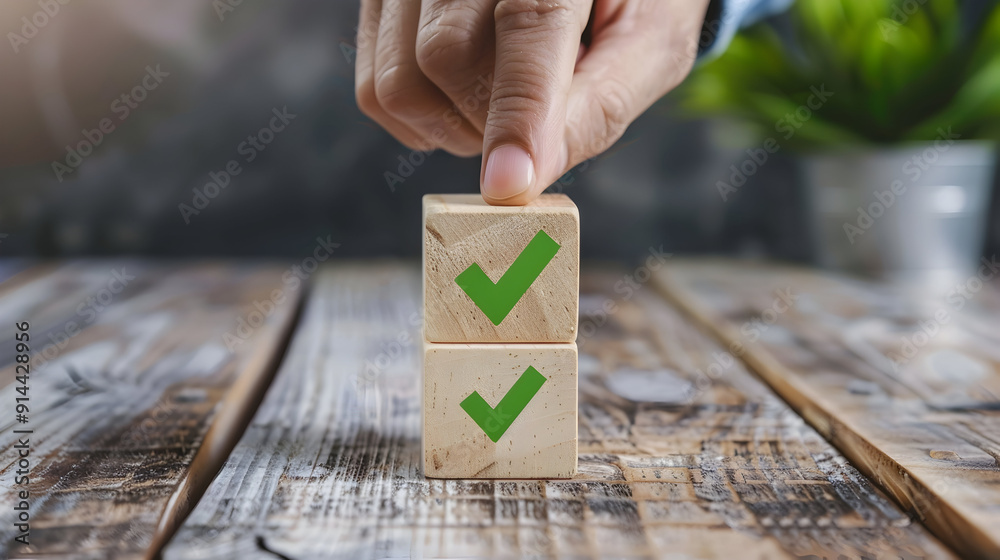 Wooden blocks checklist and green check mark icon with hand on table ...