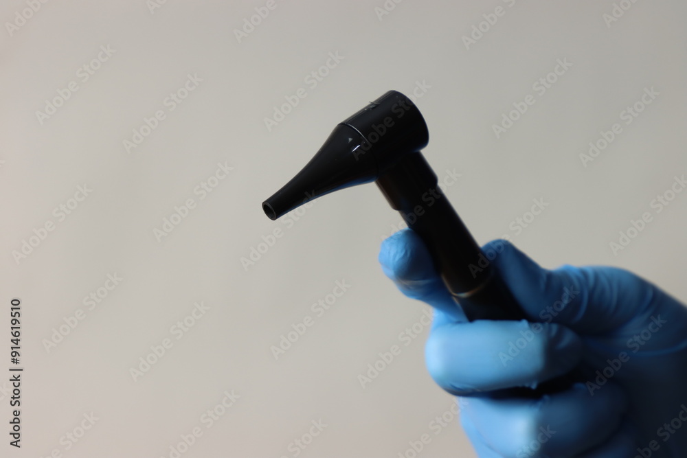 Otorrinolaringologyst professional wearing gloves holding the otoscope ...