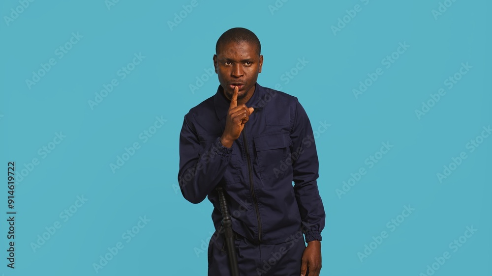 Security guard doing shush sign gesturing with finger, preventing ...