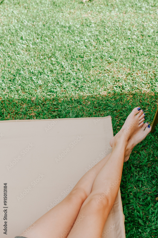 Young female legs on camping bed with green grass background. Woman ...