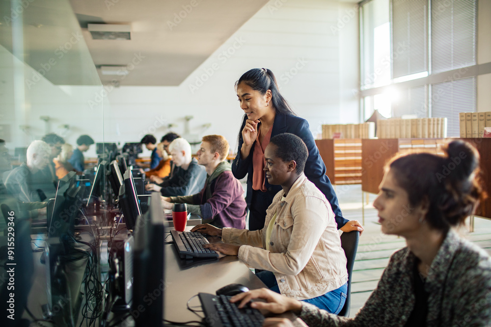 Teacher assisting students in a computer lab classroom Stock Photo ...