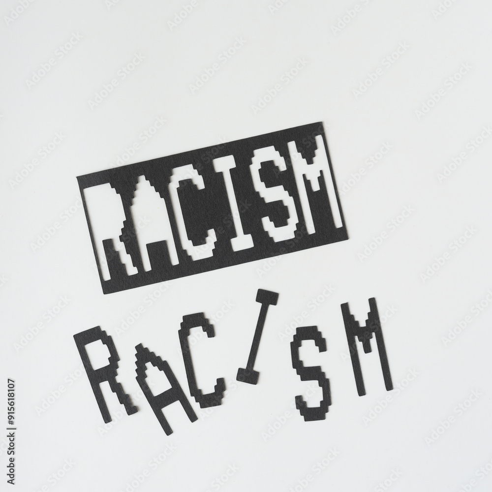 sign with the word "racism" machine-cut from black paper and arranged ...