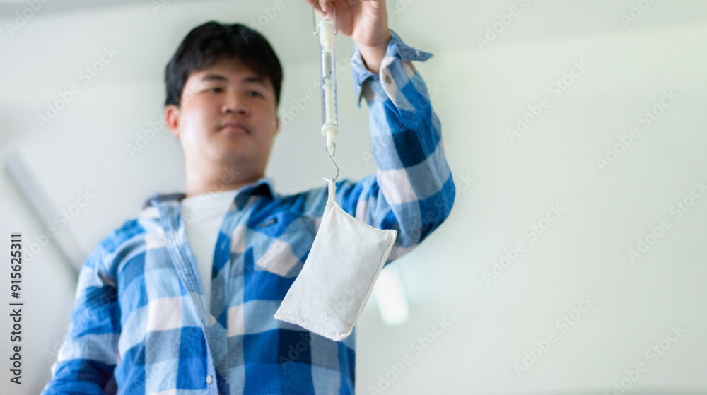 Asian student doing a physics experiment on the weight of objects using ...