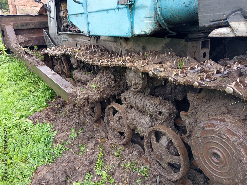 Blue large crawler tractor dirty in the swamp. A big powerful tracked ...