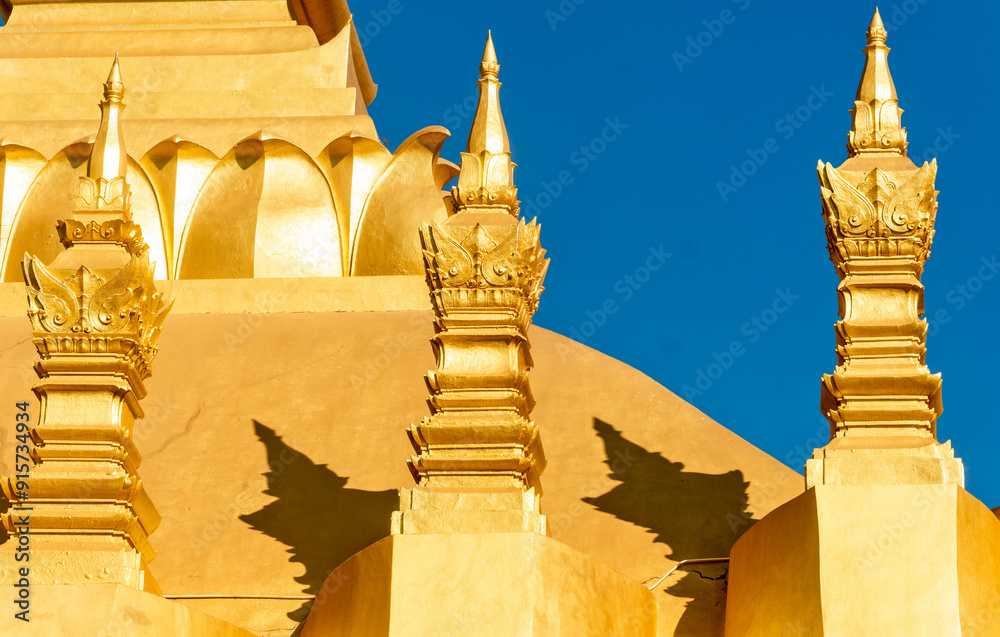 details of The stupa of Pha That Luang a large, gold-covered Buddhist ...