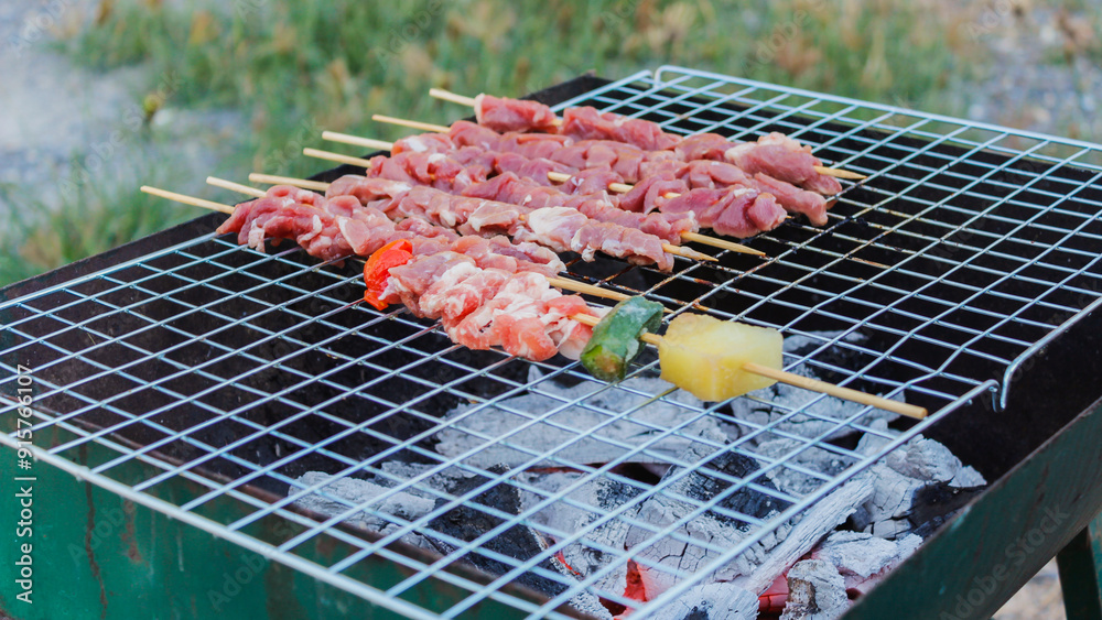 Blurred image,Barbecue (BBQ) skewered on a charcoal grill is a street food that is convenient ...