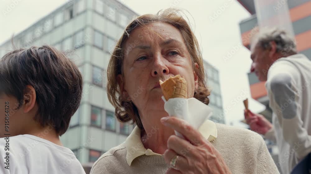 Older woman closely examining her ice cream cone while enjoying a ...
