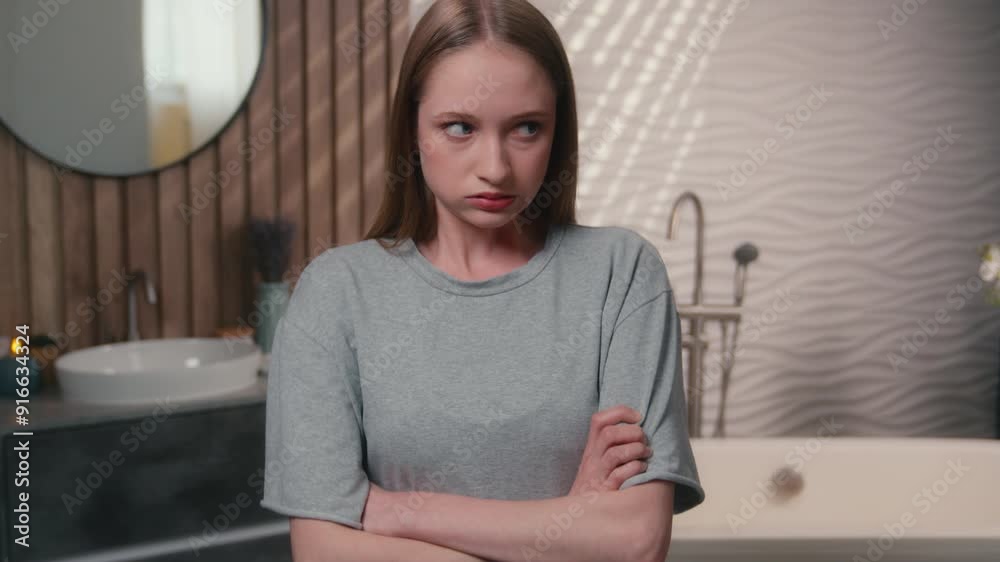 Portrait in bathroom offended angry alone sad serious Caucasian woman ...