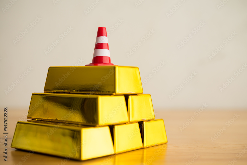 Emergency warning traffic cone on stack gold bars with white wall ...