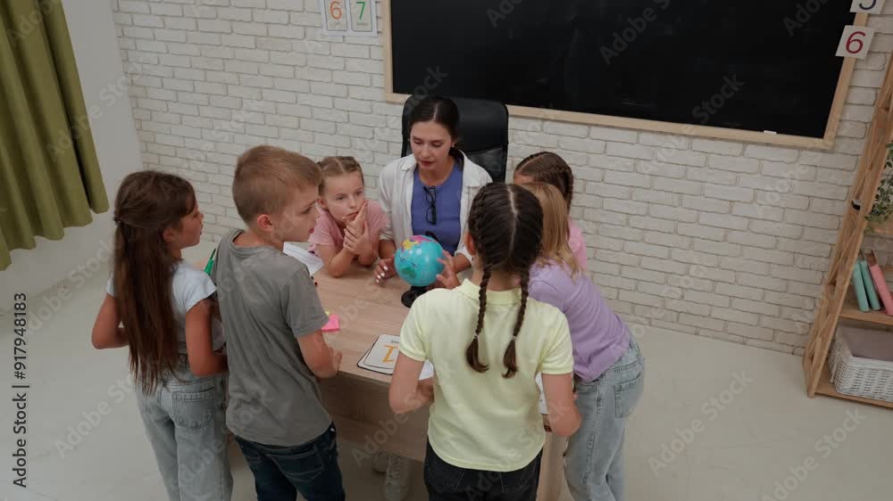 Junior school kids in classroom, woman teacher explains lesson to ...
