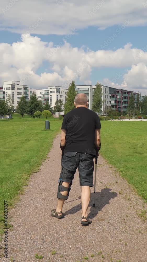 Mature man with bondage, medical splint, knee brace on the leg walking ...