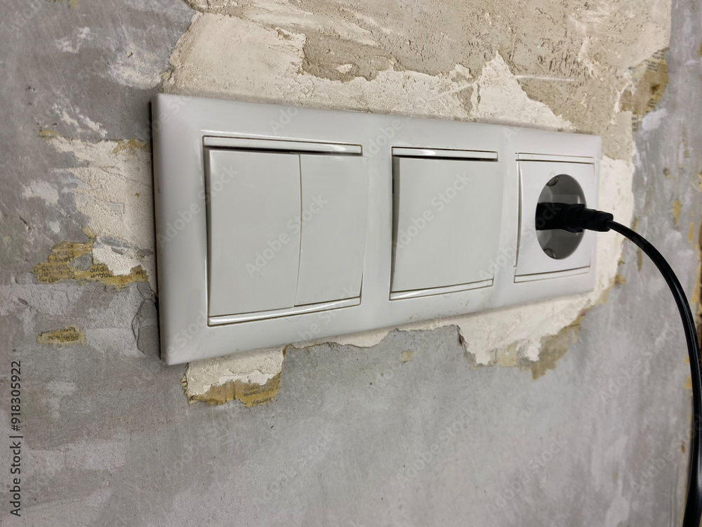 electrical outlet with cord on plain grey background for minimalistic ...