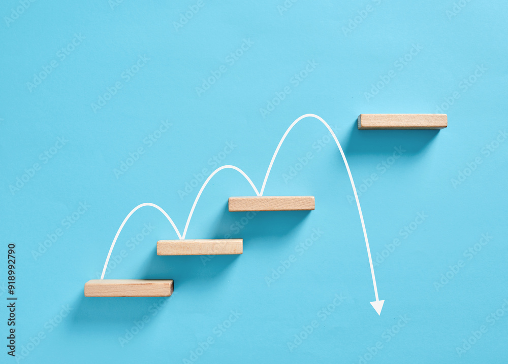 Wooden blocks arranged as stairs with a curve jumping over one step on ...