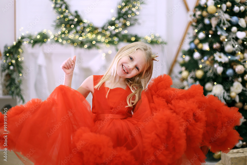 Joyful girl in red dress celebrating Christmas with enthusiasm. A young ...